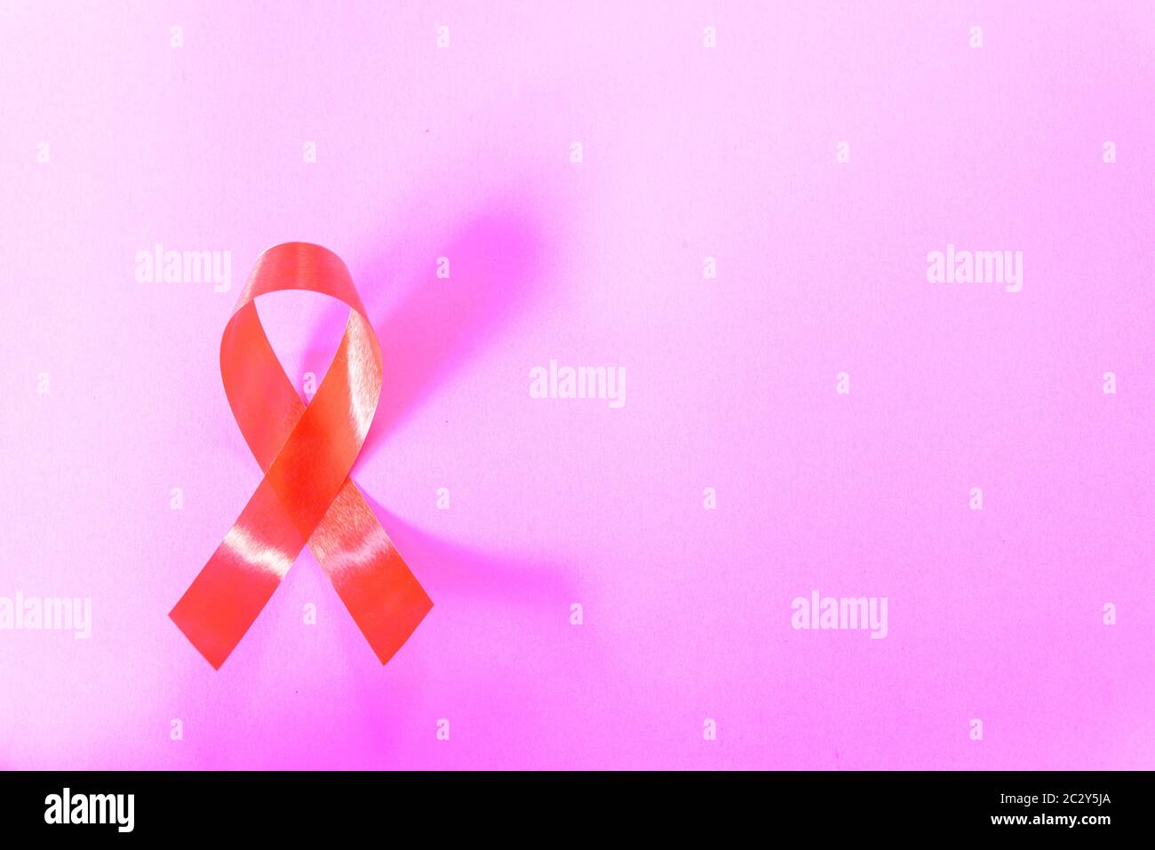 Red Ribbon Support HIV, AIDS on pink background and copy space for use ...