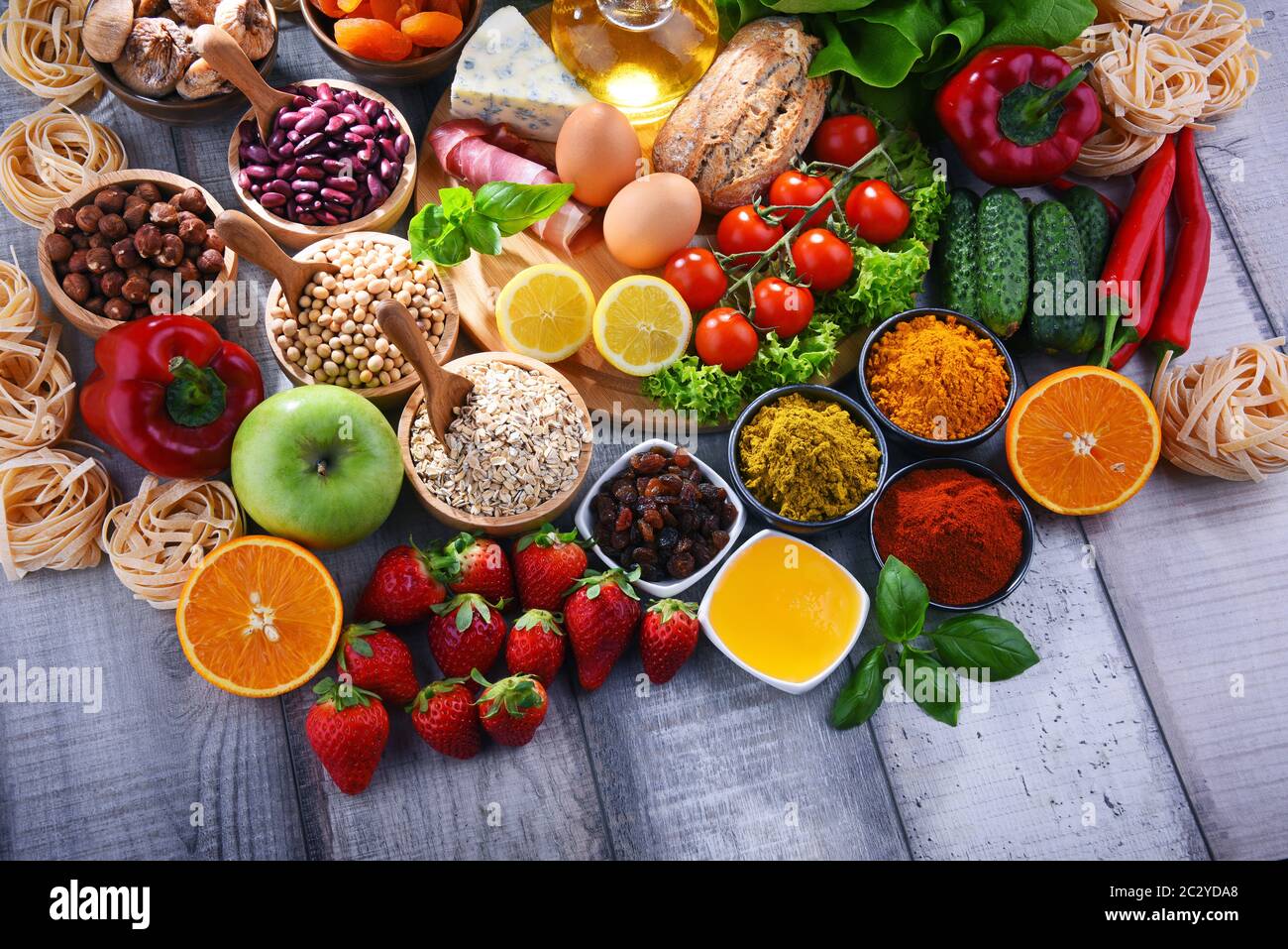 Composition with assorted organic food products on wooden kitchen table ...
