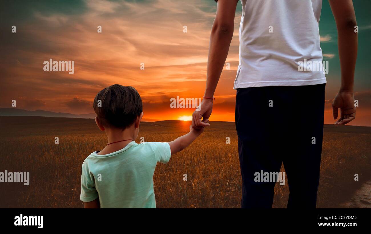 Dad holding daughter's hand looking sunset showing father's day Stock ...