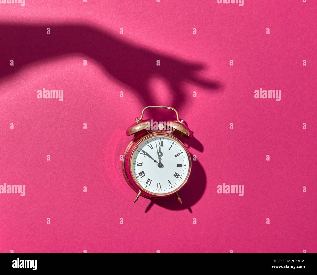 Shadow from hand holdes alarmclock Stock Photo - Alamy