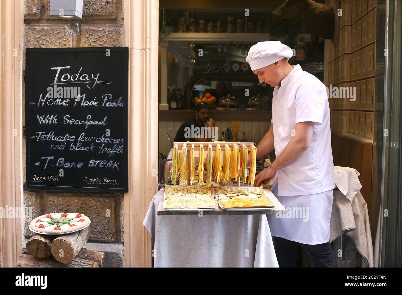 A chef prepares fresh pasta in the street for a resturant in Rome ...