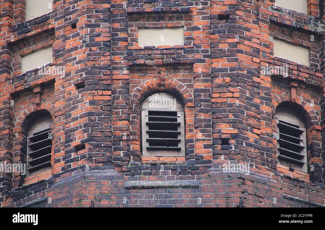 Brick wall of an old fortress with shutters and windows Stock Photo - Alamy