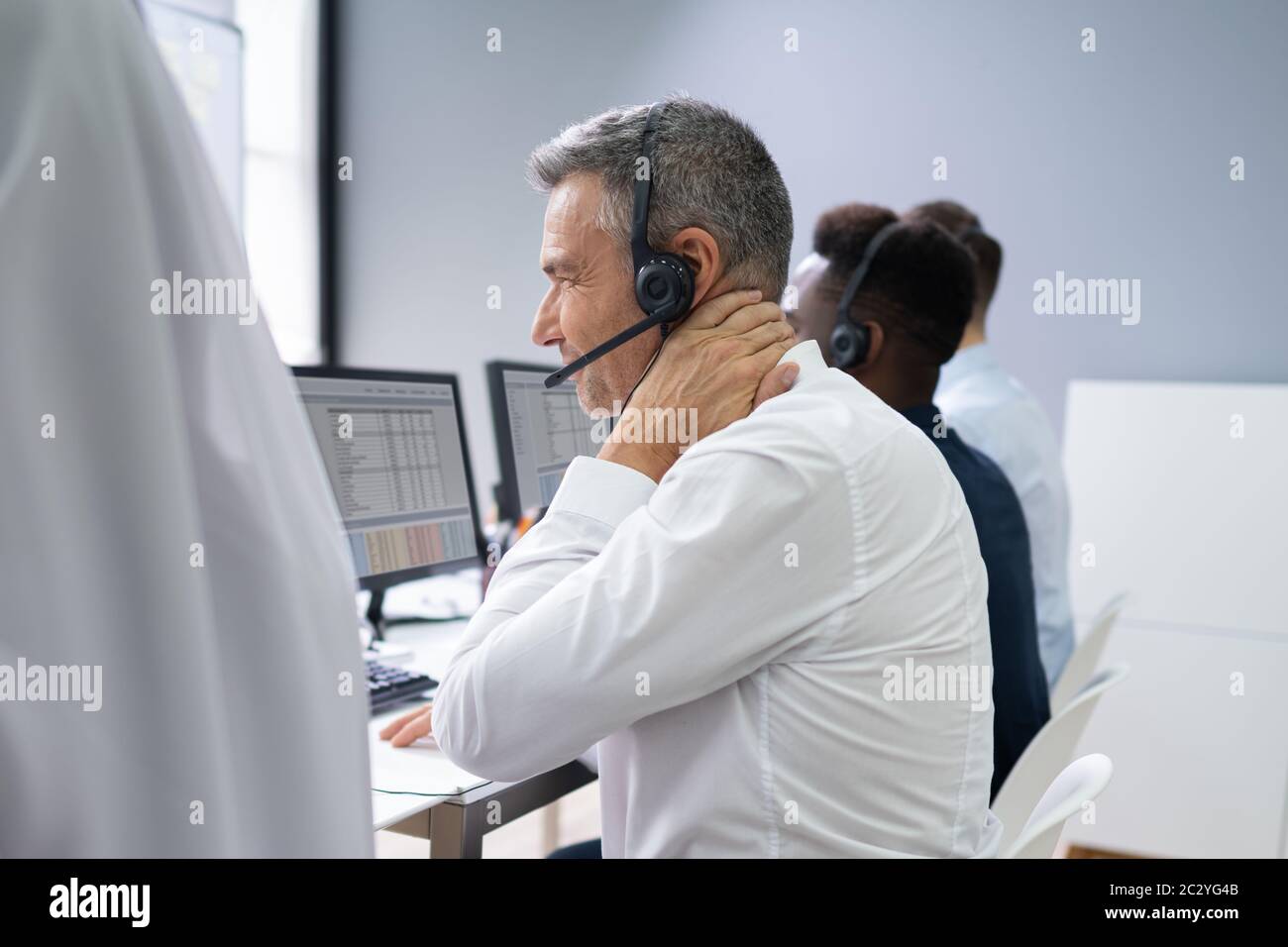 Mature Businessman Suffering From Neck Pain At Work Stock Photo - Alamy