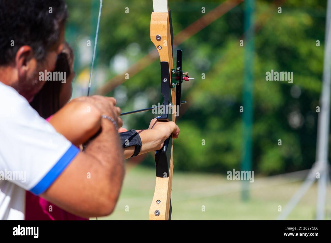 Archery course. The teacher teaches the student to aim at the goal ...