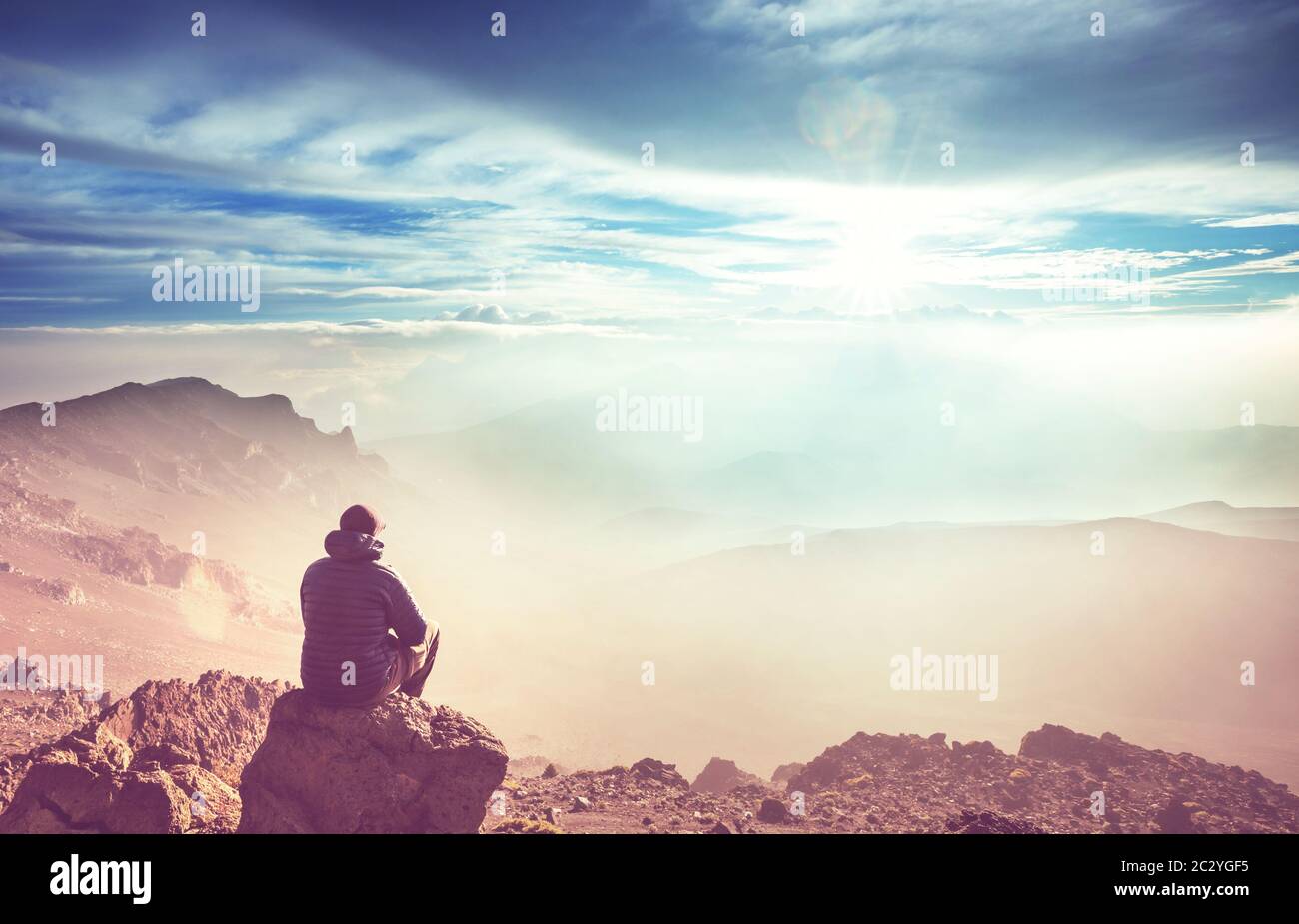 Relaxing man in the mountains at sunrise Stock Photo - Alamy