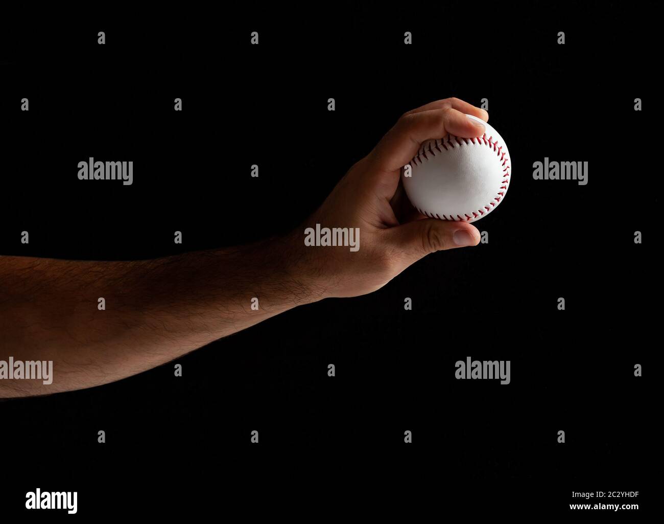 Baseball pitcher, close up of the hand ready to pitch on black ...