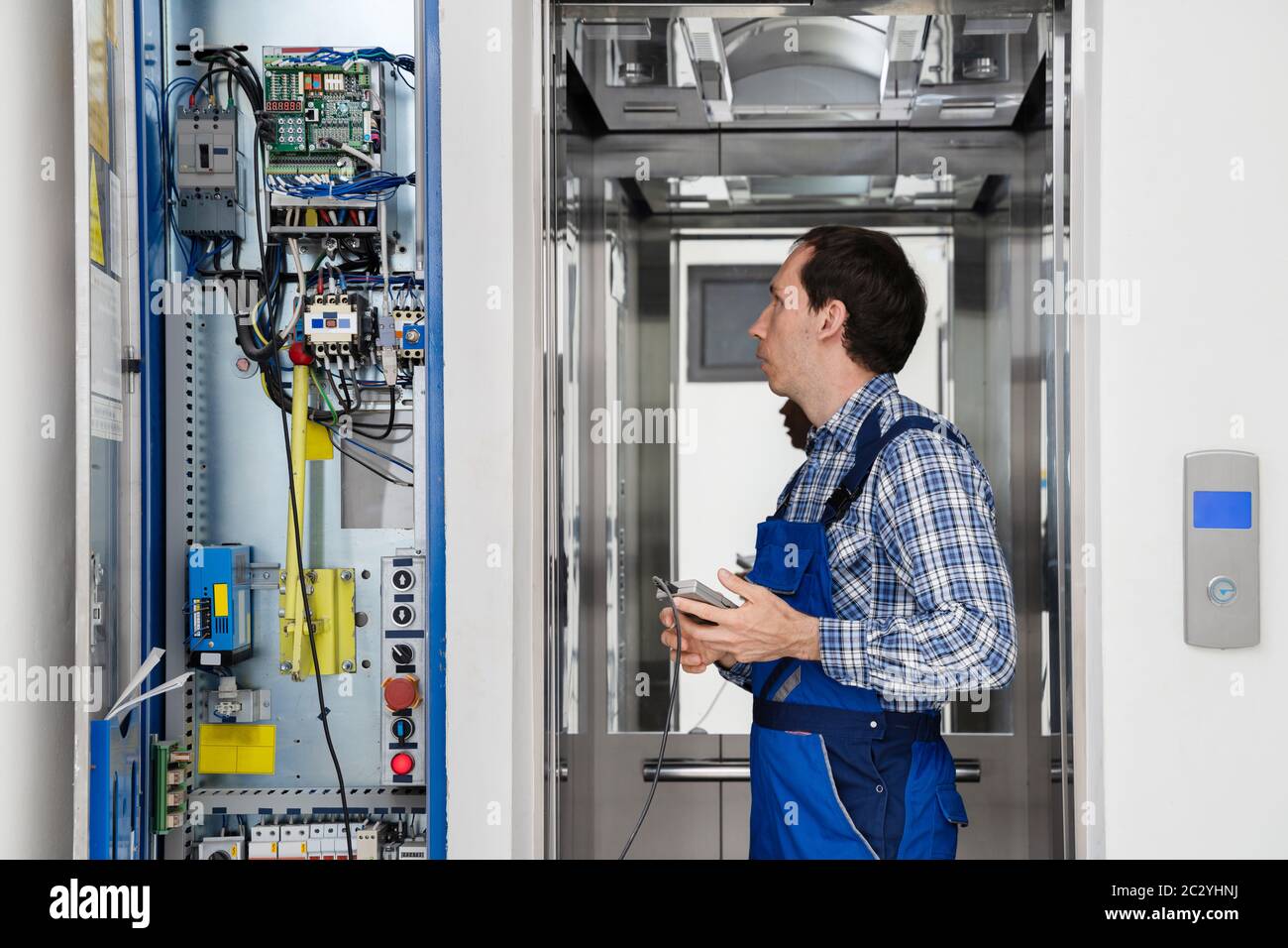Technician Repairing Control Panel Of Broken Elevator Stock Photo - Alamy