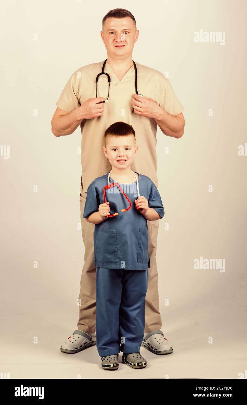 Future profession. Want to be doctor as dad. Cute kid play doctor game ...