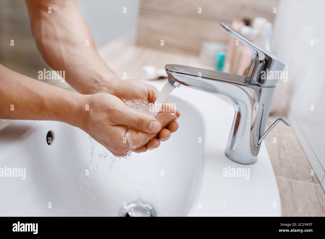 Man washes his face in bathroom, routine morning hygiene. Male person ...