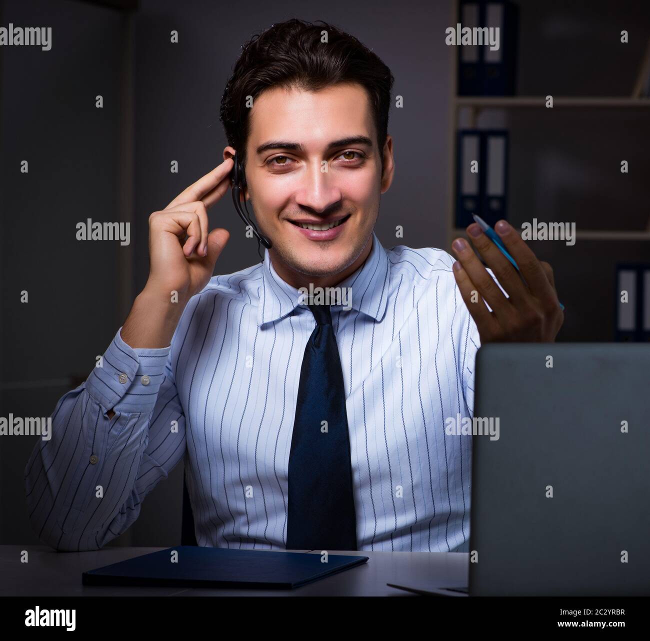 Call center operator talking to customer during night shift Stock Photo ...