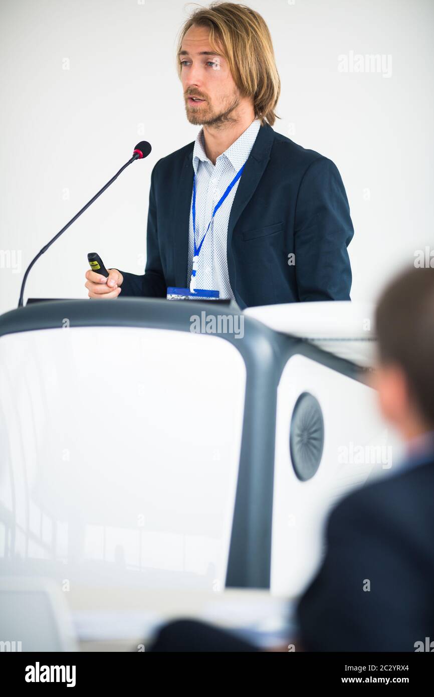 Handsome young man giving a speech at a conference Stock Photo - Alamy