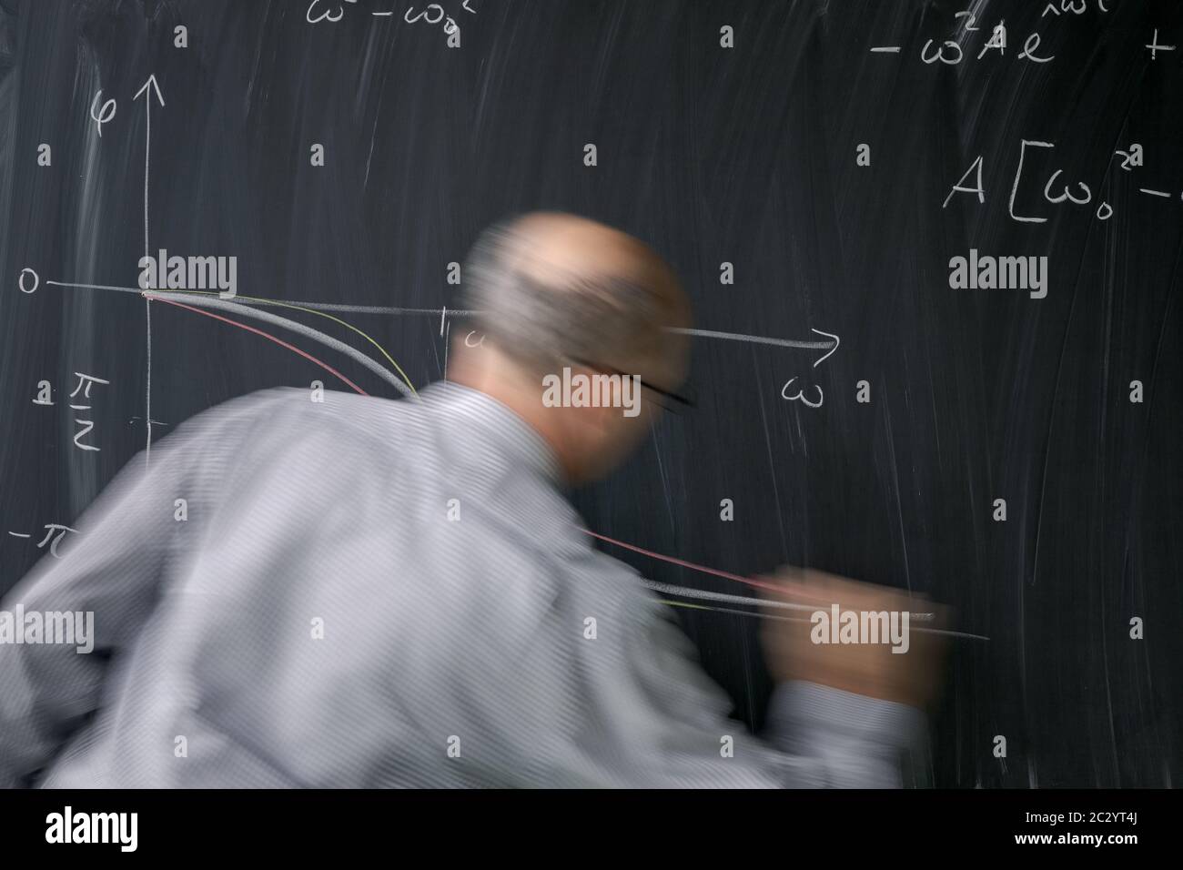 Math teacher drawing fuction graph on a blackboard during mathclass ...