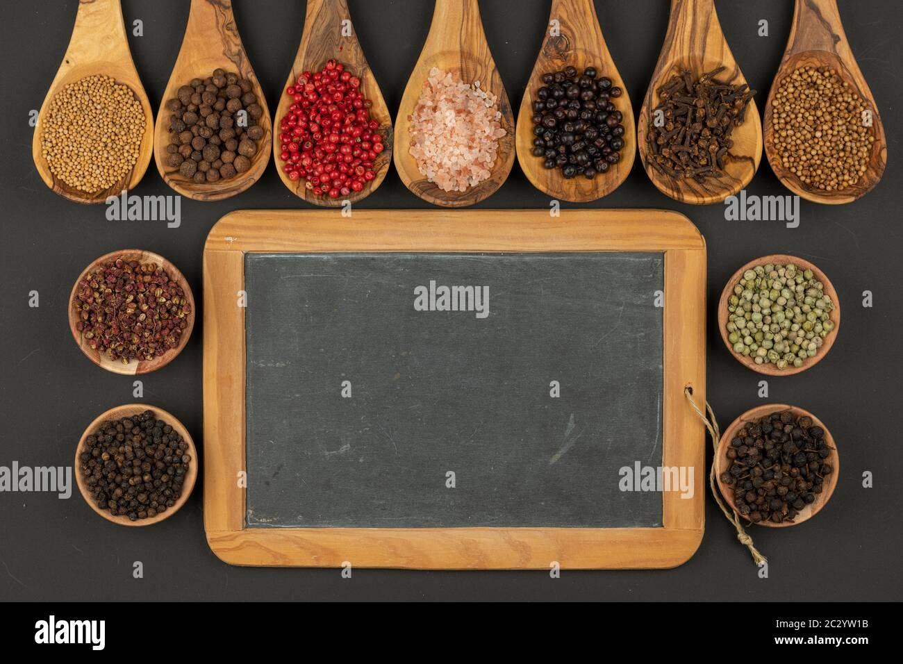Seven cooking spoons made of olive wood and four small wooden bowls ...
