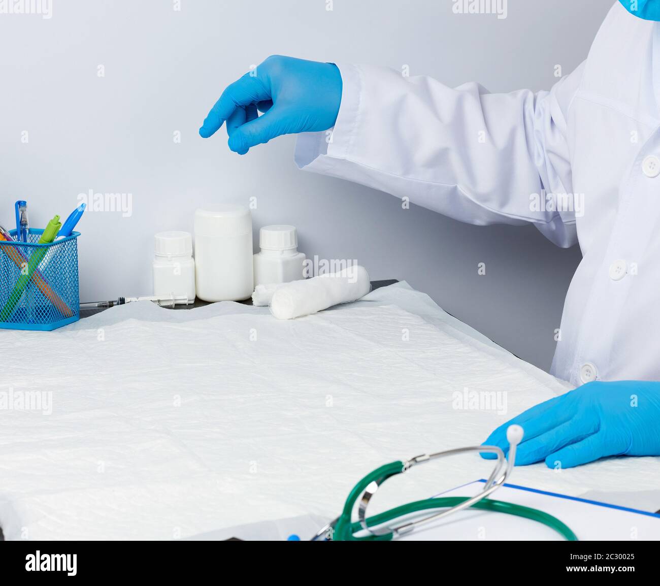 doctor in a white medical coat sits at a table, workplace for receiving ...
