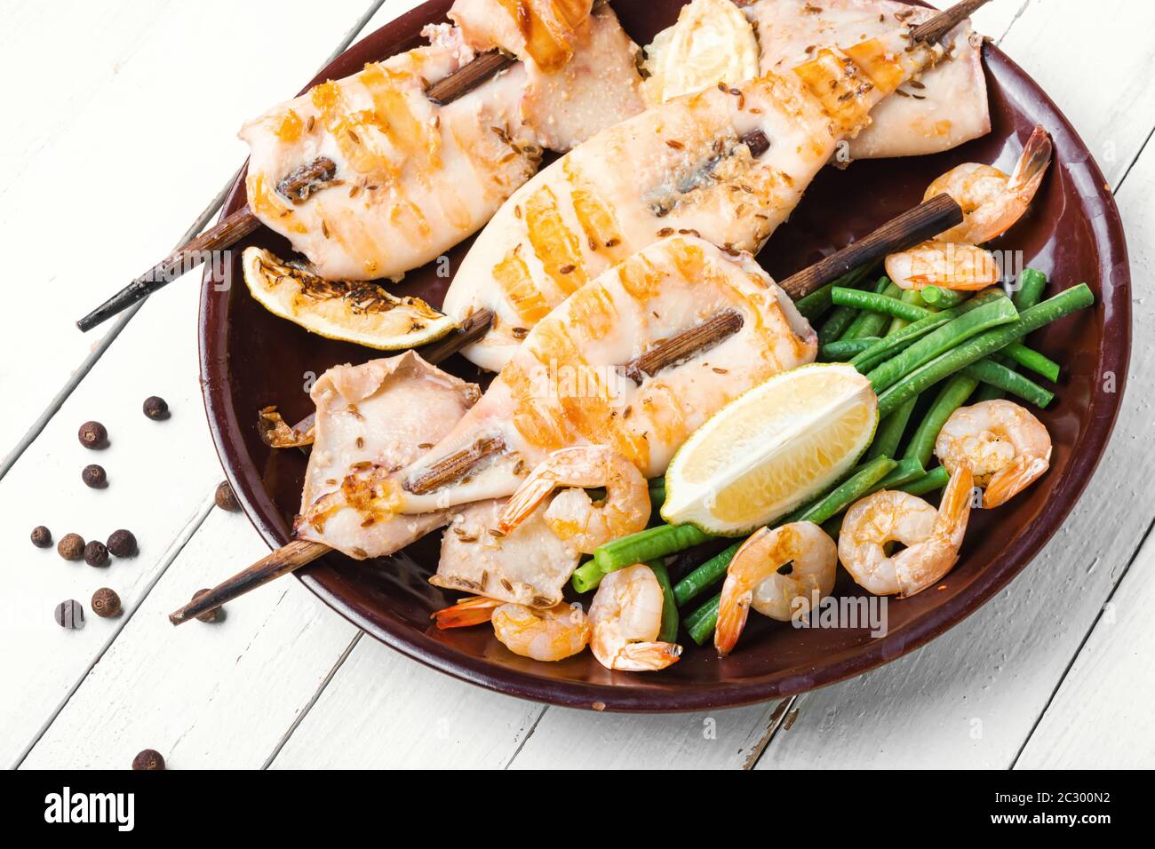 Grilled squid or calamari on skewer.Barbecue squids on a plate Stock ...