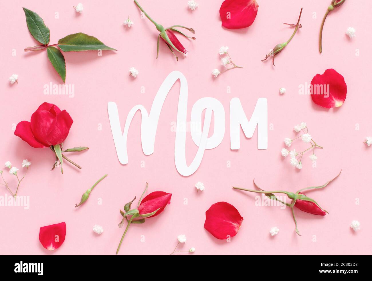 Red roses flowers and word MOM on a light pink background top view ...