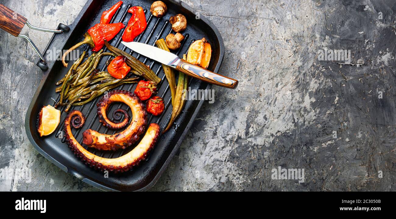 Grilled octopus with roasted vegetables in grill pan.Copy space Stock ...