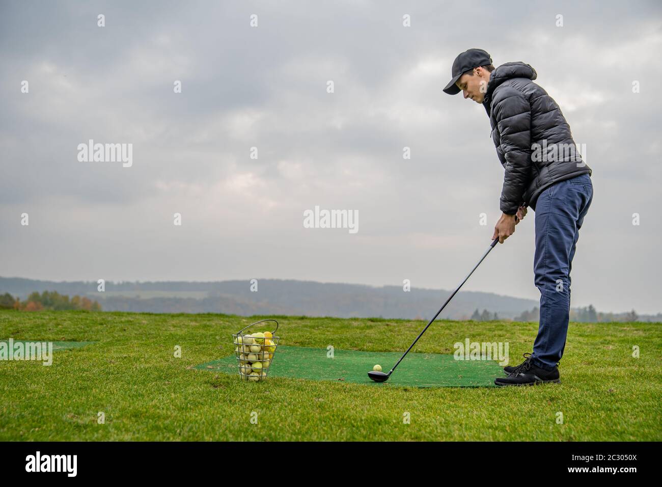 golfer on a green pitch batting golf ball Stock Photo - Alamy