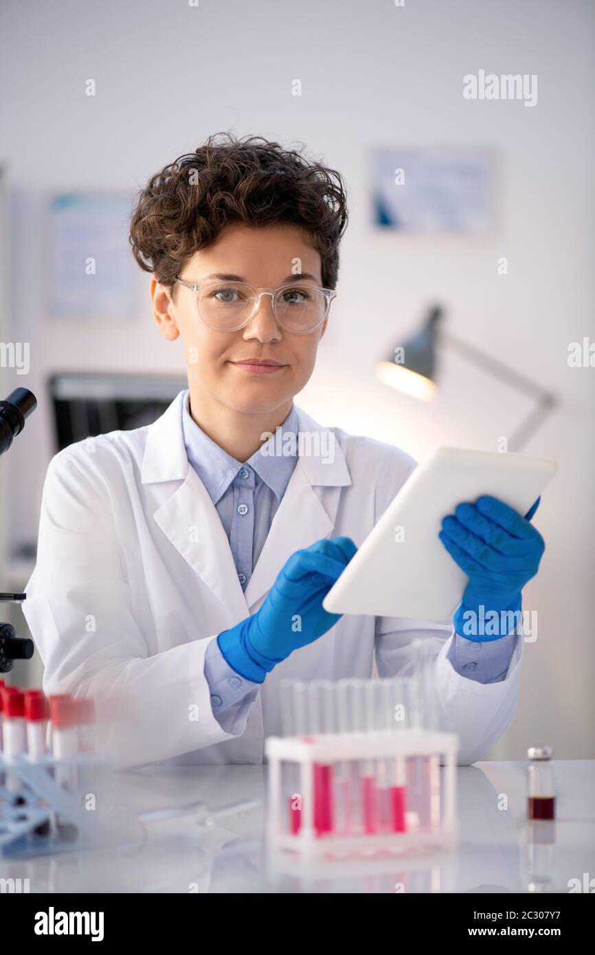 Portrait of confident pharmaceutical researcher in lab coat and goggles ...