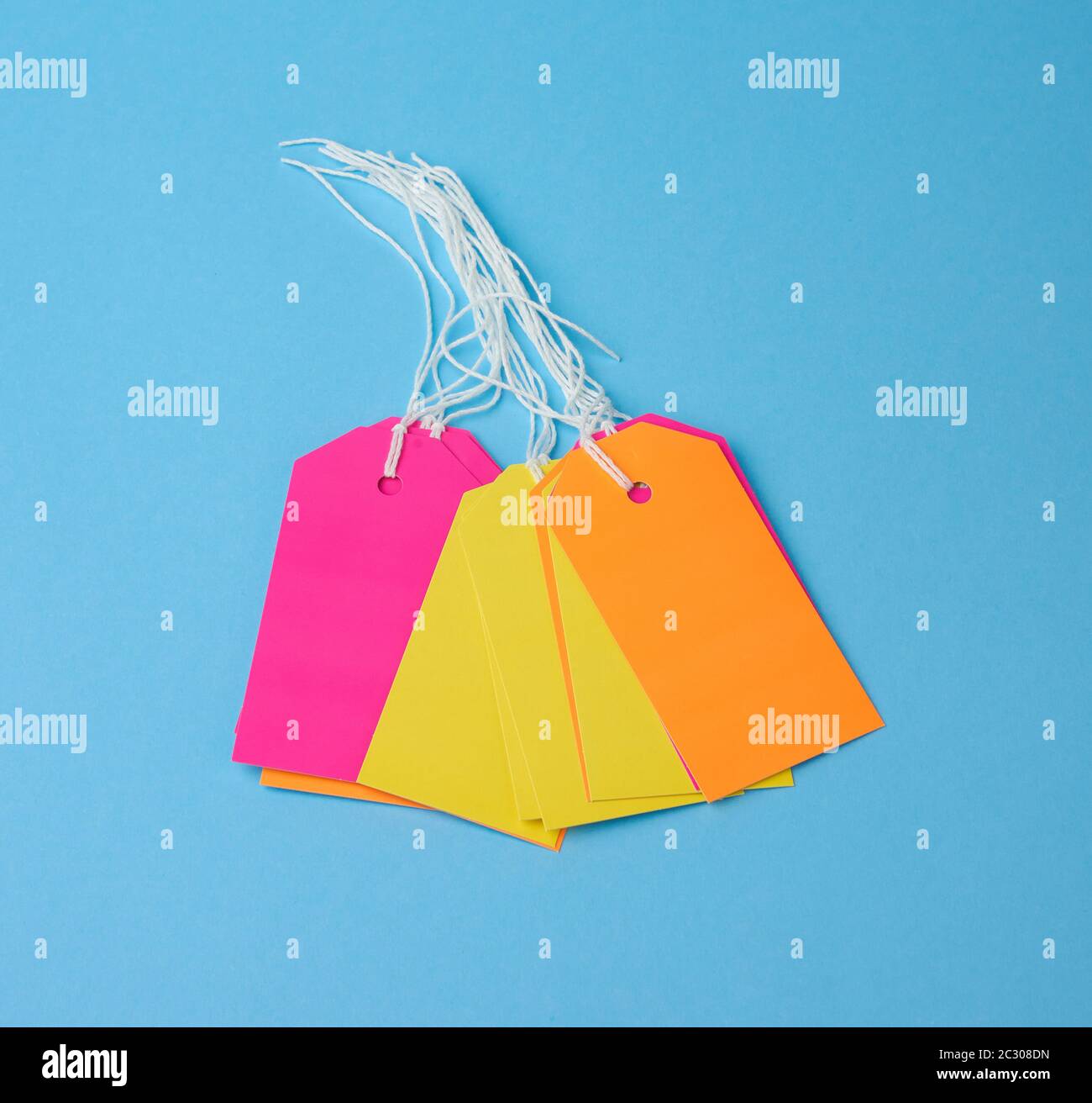 Stack empty color paper tags tied with white string. Price tag, gift ...