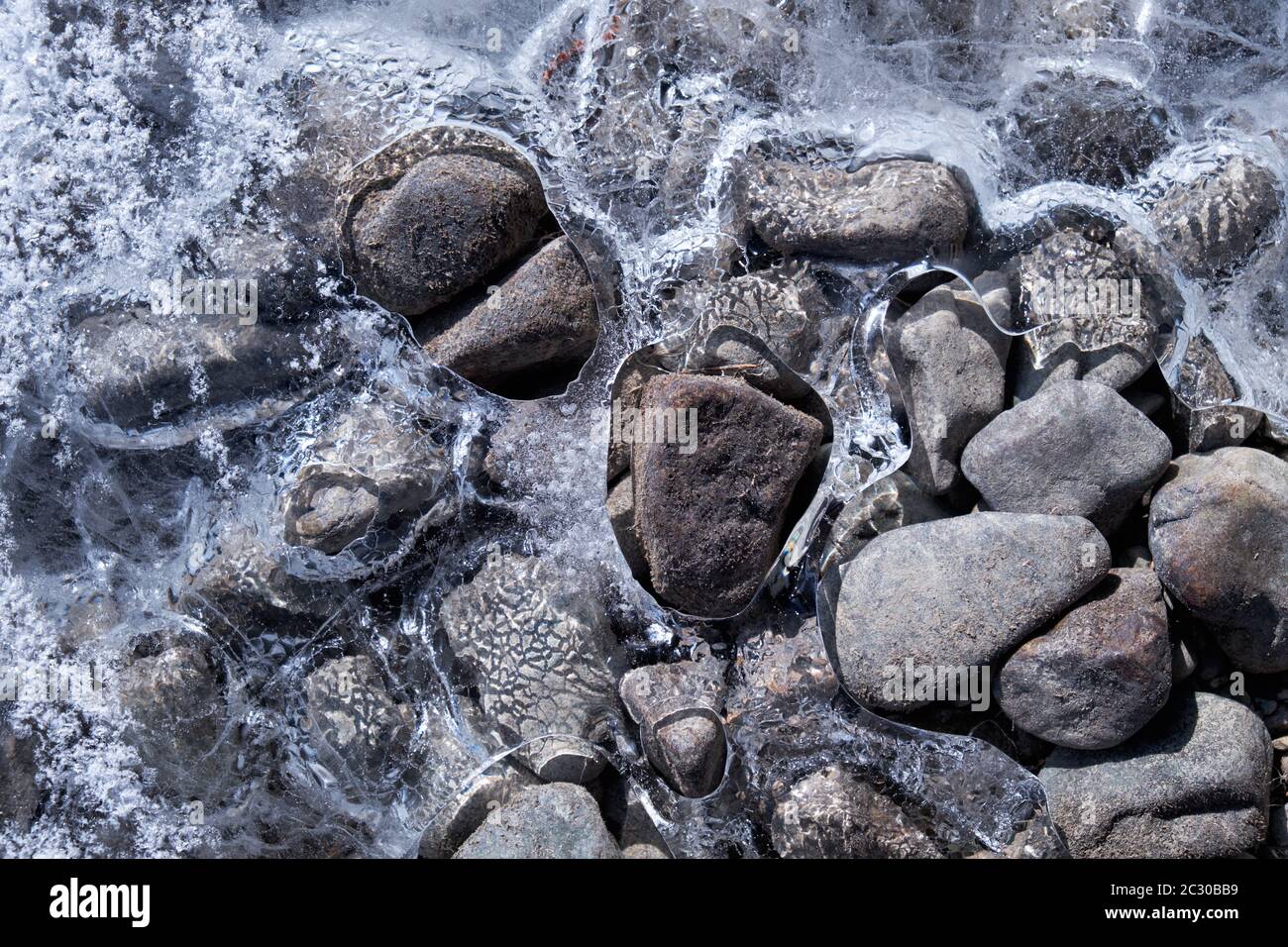 Natural winter background of frozen pebbles and hoarfrost crystals over ...