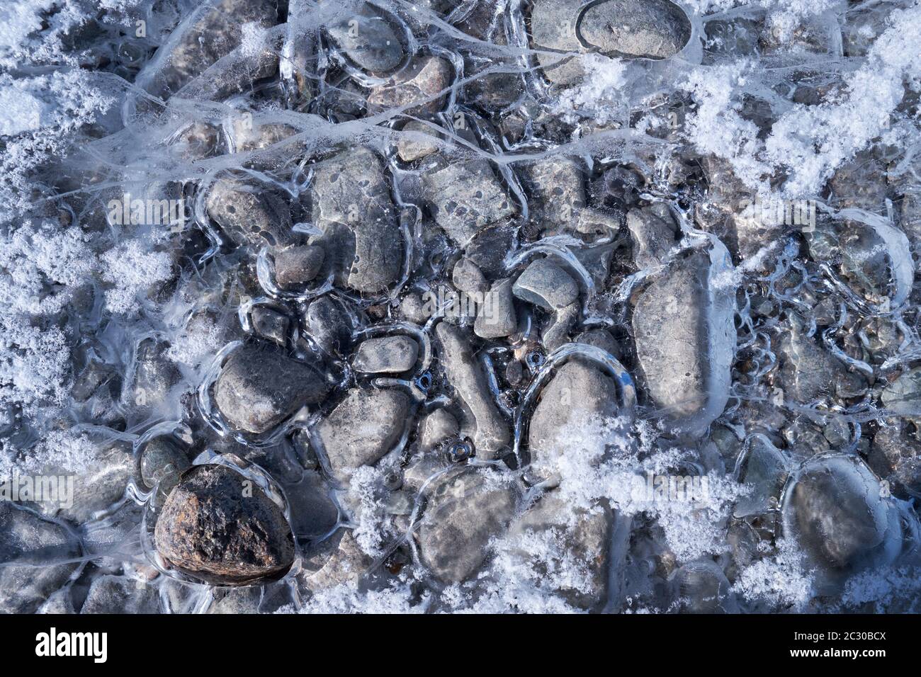Natural winter background of frozen pebbles and hoarfrost crystals over ...