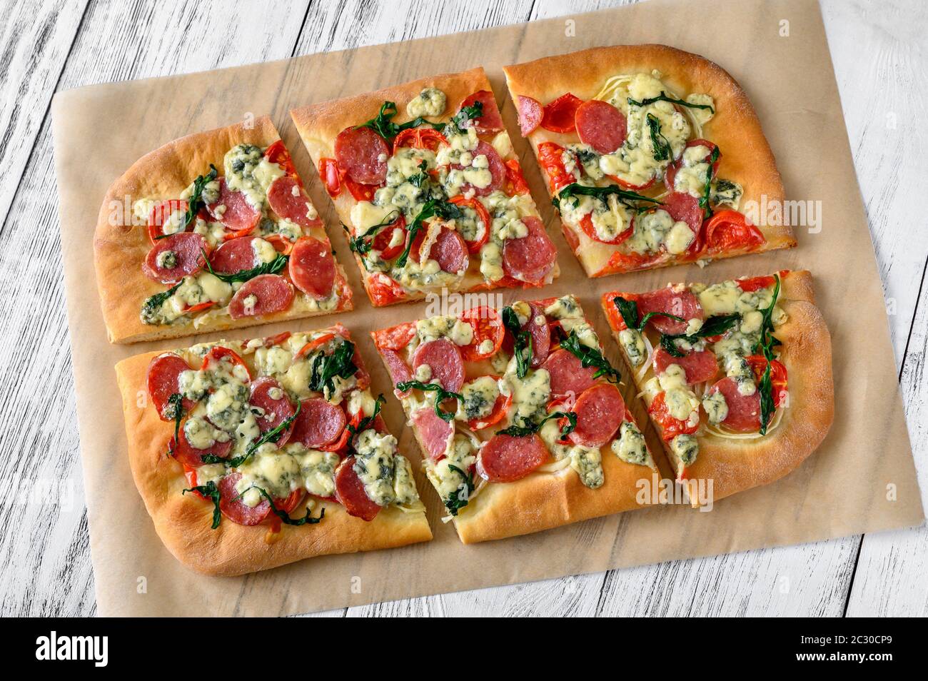 Spanish coca with blue cheese, fuet and arugula Stock Photo - Alamy