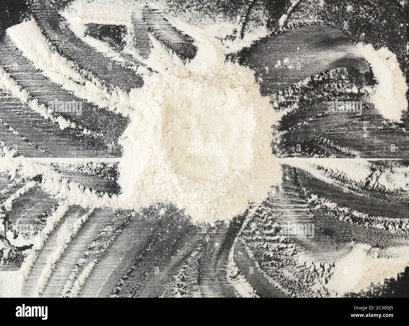 white wheat flour scattered on a black table, in the middle a circle ...