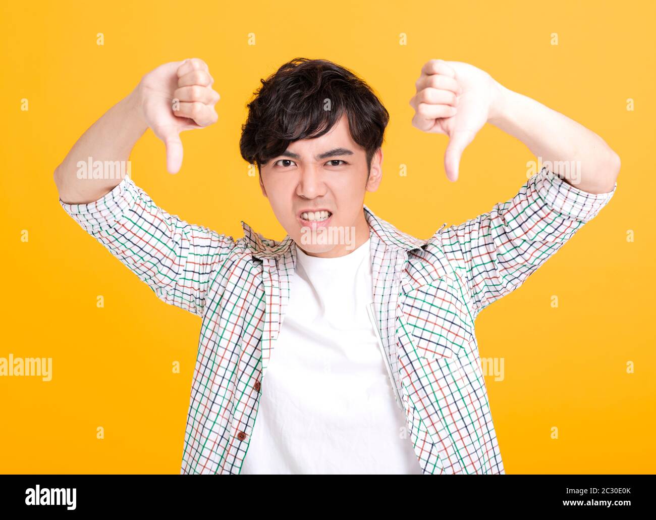 Young man thumbs down yellow hi-res stock photography and images - Alamy