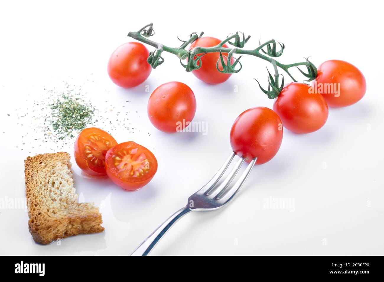 Round cherry tomato pricking with a fork in a healthy breakfast Stock ...