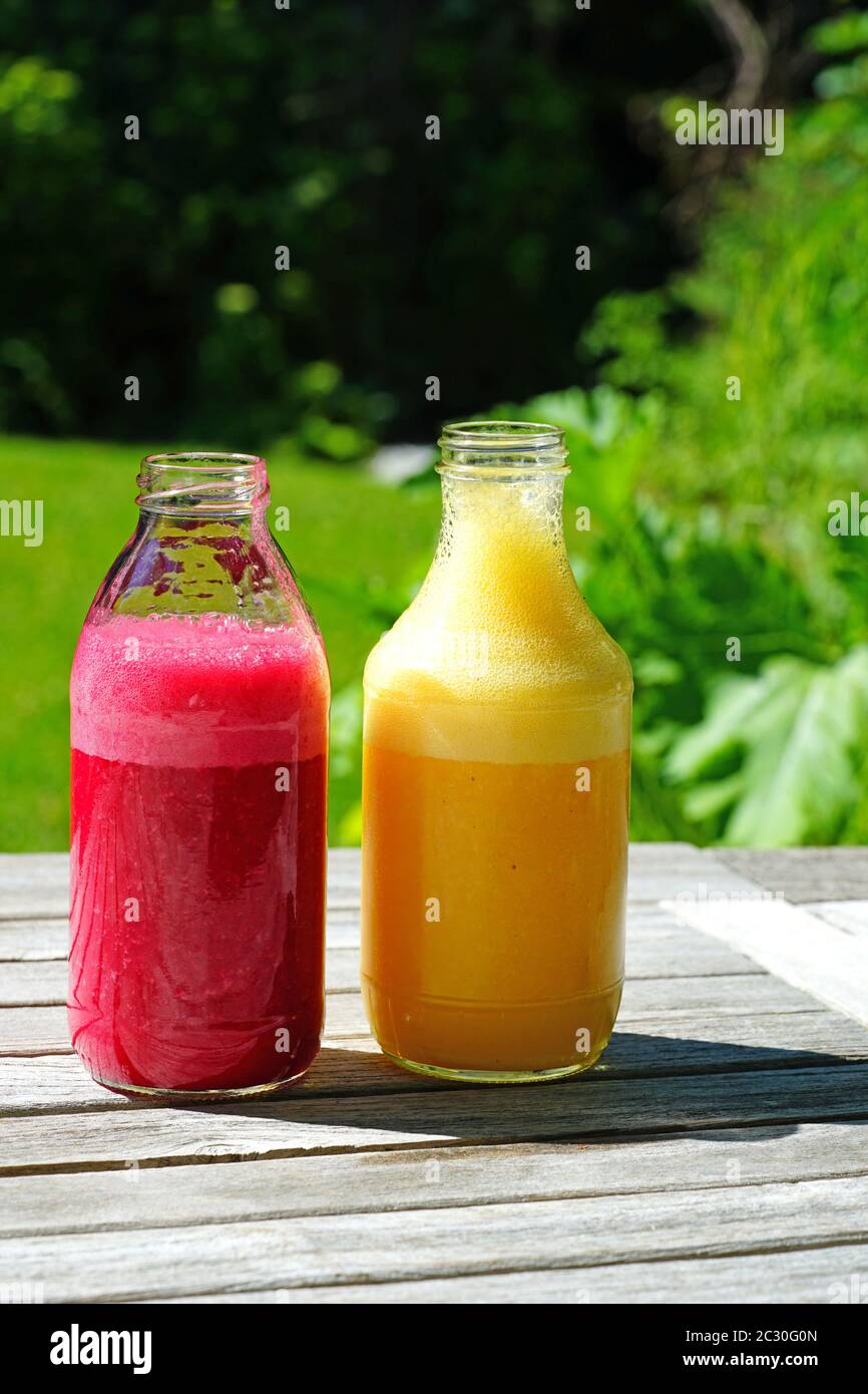Glass bottles filled with colorful fresh homemade beet and peach ...