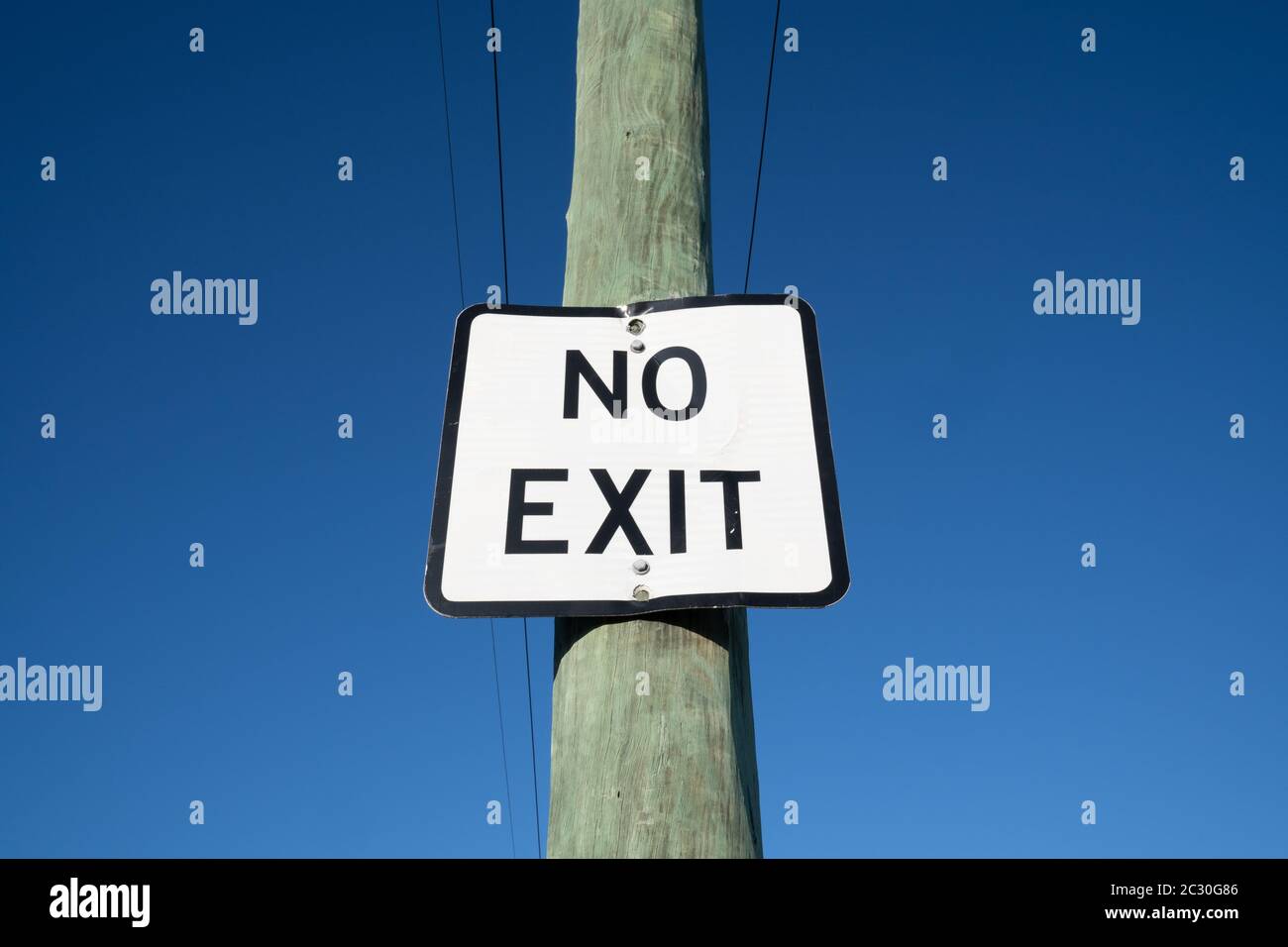 No exit sign hang on wooden electric pole with blue sky Stock Photo - Alamy