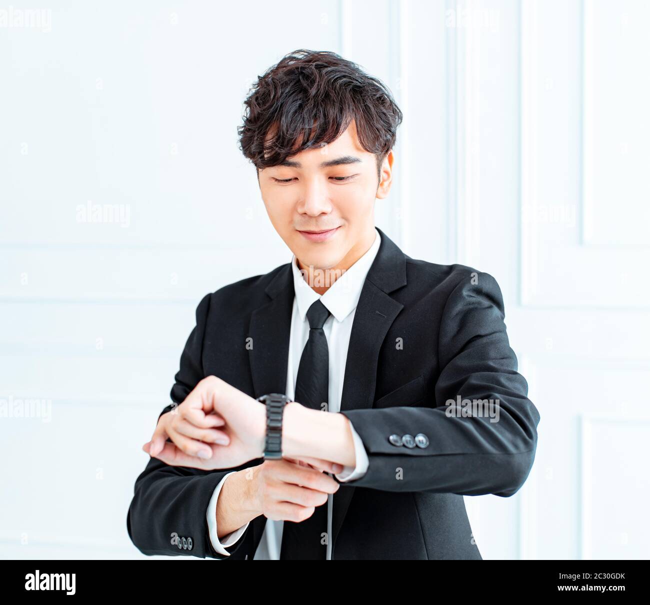 Business man looking at watch in office Stock Photo - Alamy