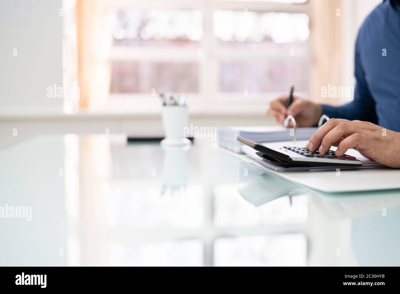 Young businessman holding calculator checking hi-res stock photography ...