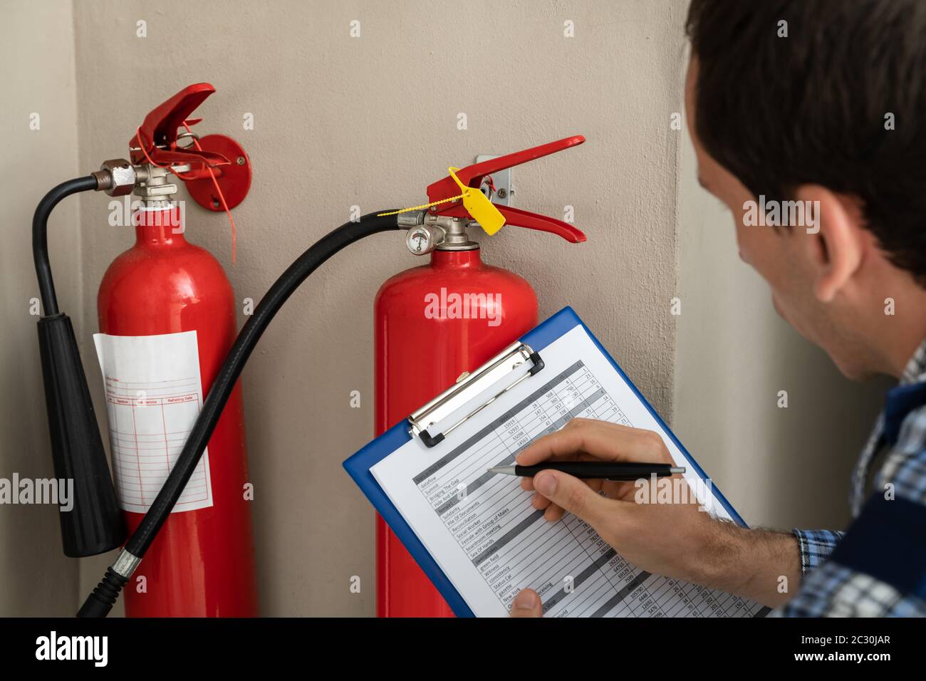 Male Professional Checking The Condition Of A Fire Extinguisher Stock ...
