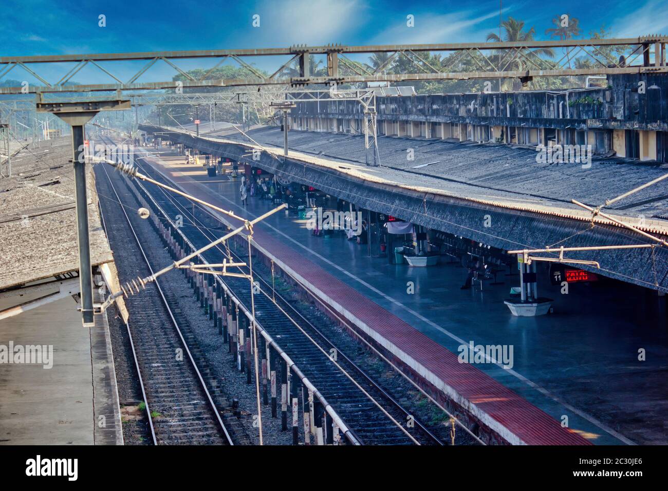 A side ariel view of an Indian railway station platform before blue sky ...