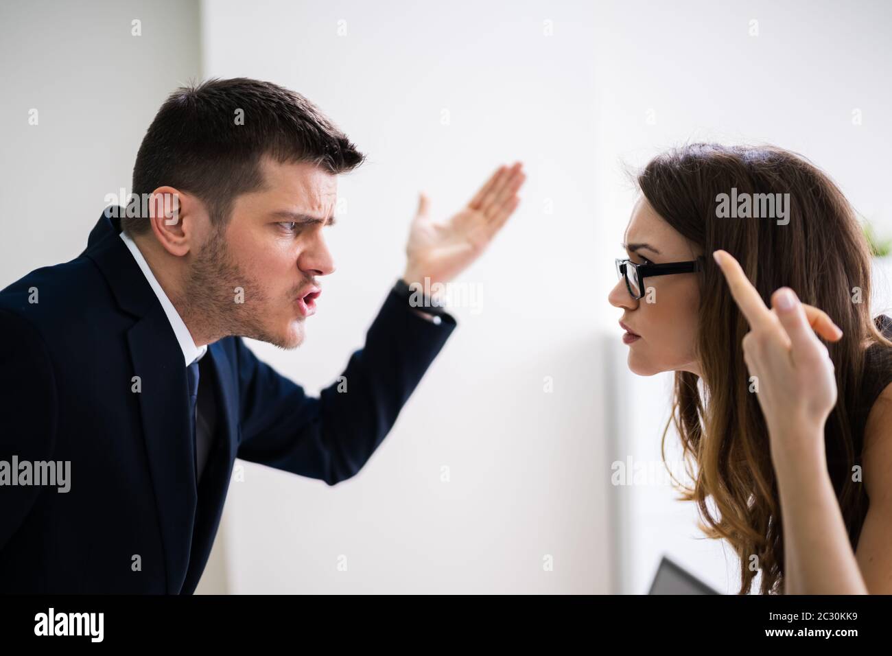 Side View Of Business People Quarreling At Desk In Office Stock Photo ...