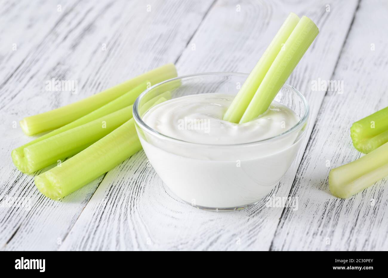 Leaf celery stalk dipped in Greek yogurt Stock Photo - Alamy