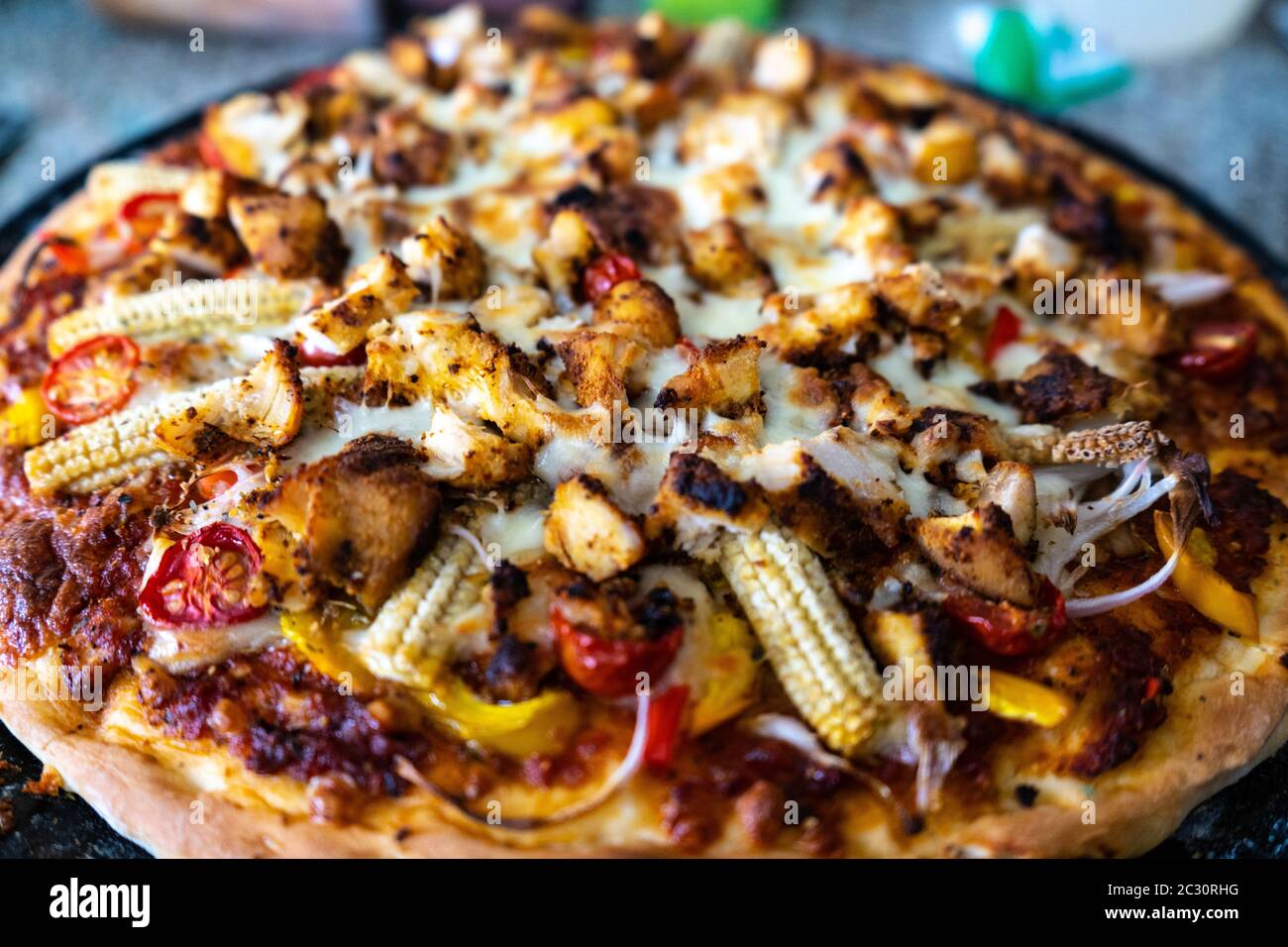Top view of home made pizza with sauce, vegetables, baby corn, corn ...