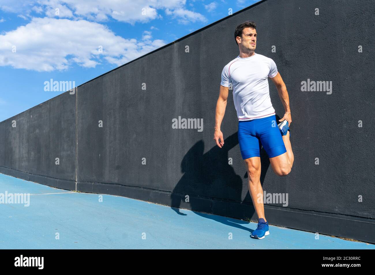 Young man running in blue pants and white shirt resting and recovering ...