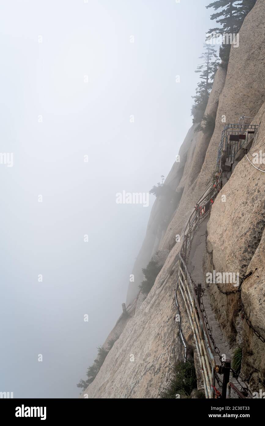 Stone steps cut on a side of a mountain rock leading to the dangerous ...