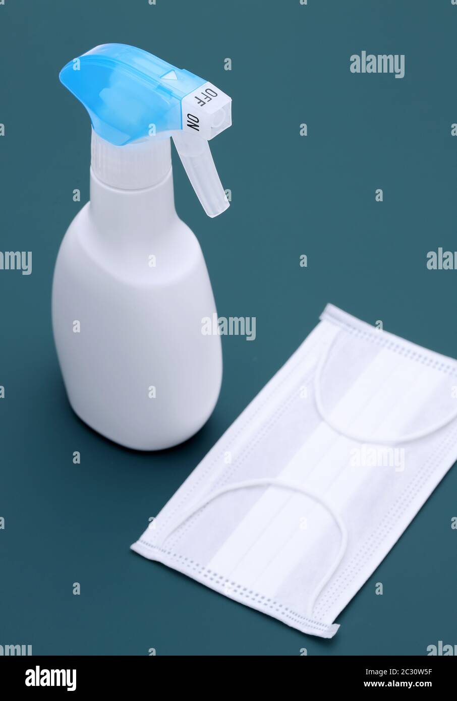 Disinfection spray with protection face mask on the color background ...
