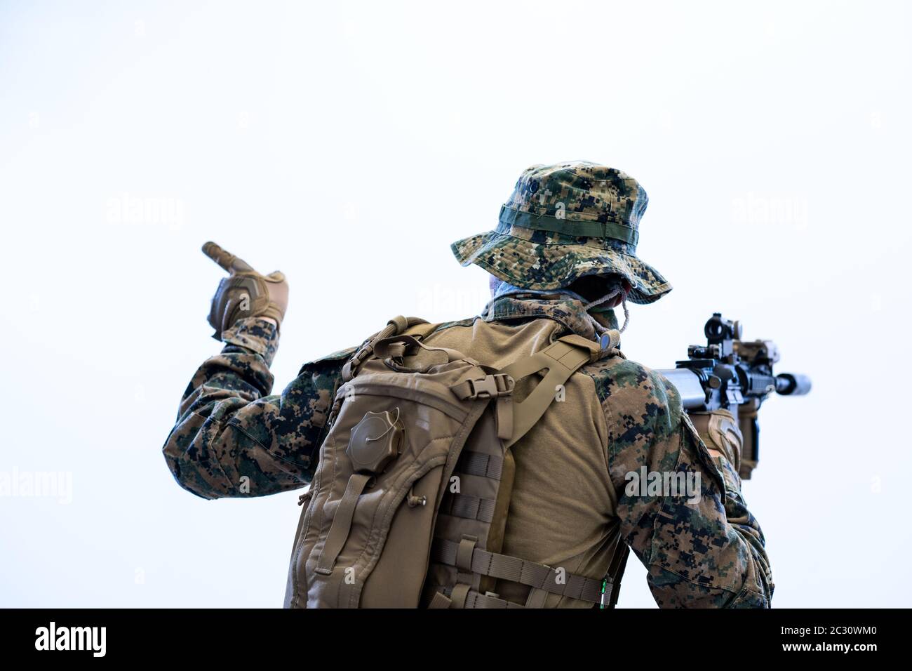 soldier in action giving comands to team by hand sign Stock Photo - Alamy
