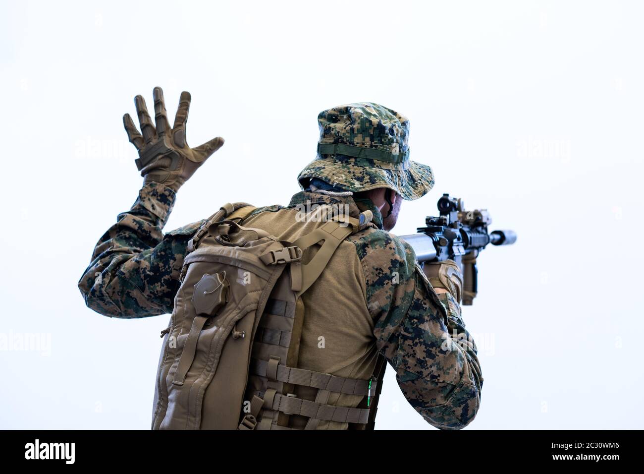 soldier in action giving comands to team by hand sign Stock Photo - Alamy