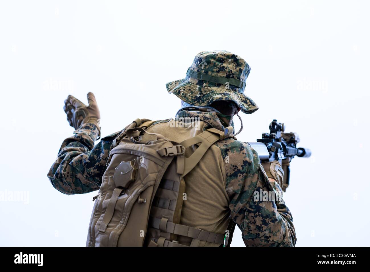 soldier in action giving comands to team by hand sign Stock Photo - Alamy