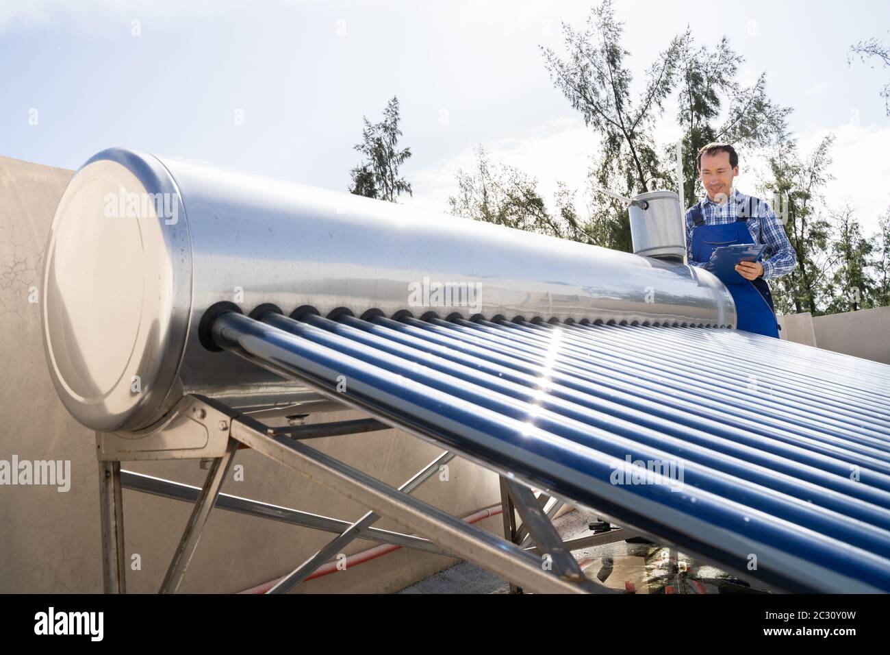 Male Plumber Doing Solar Energy Boiler Inspection Stock Photo - Alamy