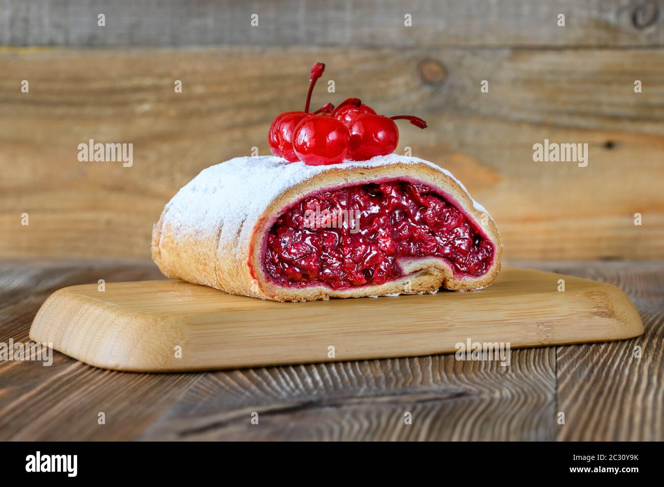 Strudel with cherry filling on wooden background Stock Photo - Alamy