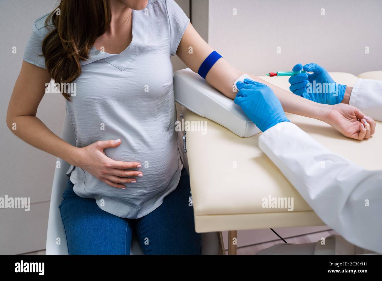 Close-up Of Doctor Injecting Pregnant Female Patient With Syringe To ...