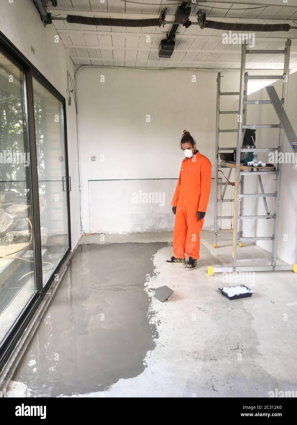 Young worker wearing orange suit at work on a restoring site, Bron ...