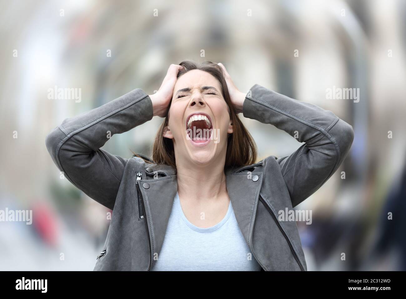 Front view portrait of a stressed woman screaming desperate suffering ...